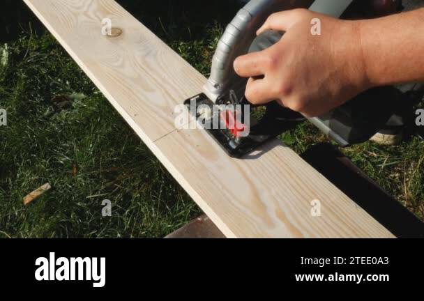 Cutting wood planks with a circular. A carpenter works with wooden ...