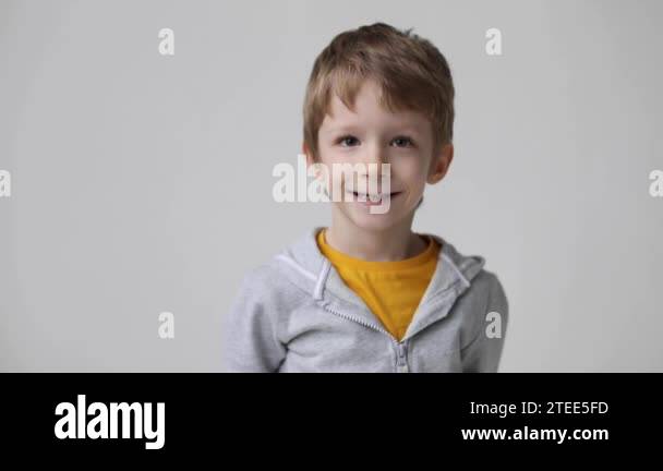 Cute little boy shows thumbs up gesture, happy facial expression ...