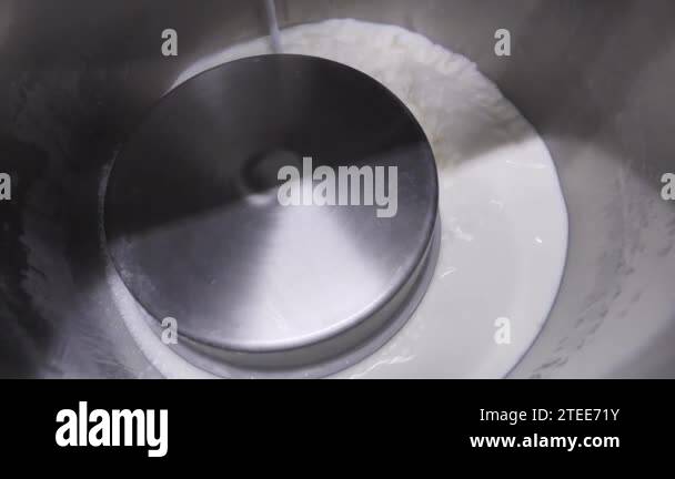 Inside steel vat, filling factory cauldron with milk for pasteurization ...