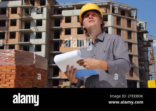 Man comparing plan with process of building Stock Video Footage - Alamy