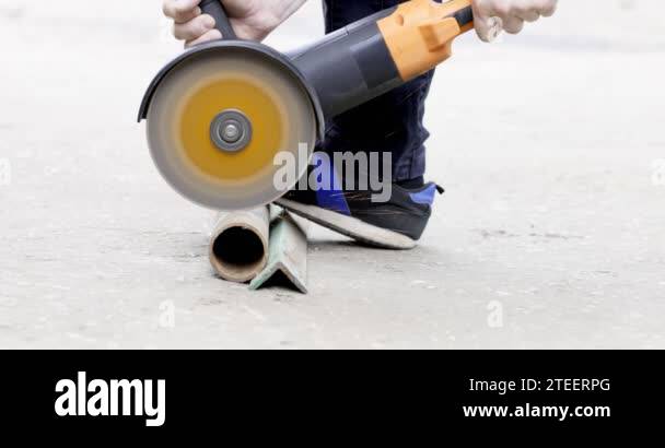 Foreman using angle grinder and cutting a metal tube. Artisan cuts ...