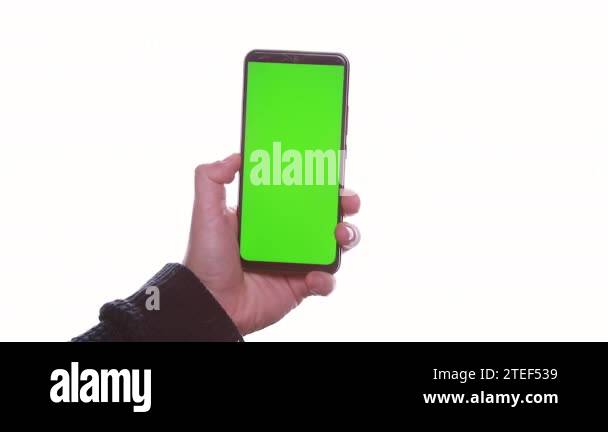 man's hand holding a smartphone with a vertical green screen in tram chroma key smartphone ...