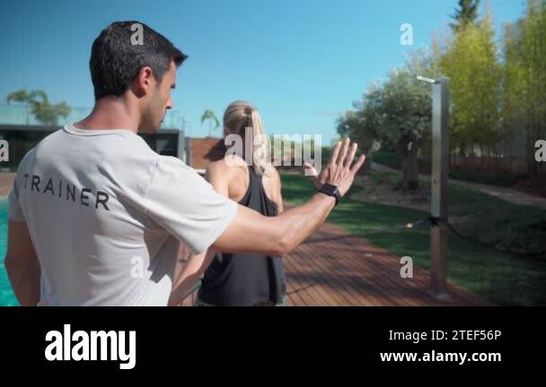 Young athletic fitness woman and personal trainer doing exercises to ...