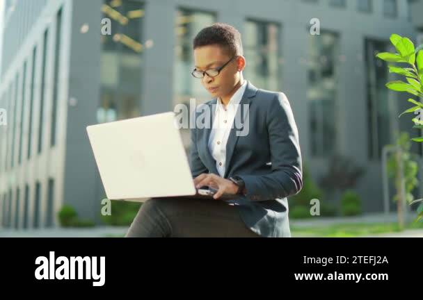 young African American business woman freelancer sitting on bench ...