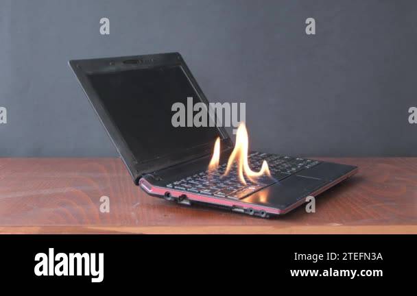In the room on the table, a laptop caught fire, flames and sparks, a ...