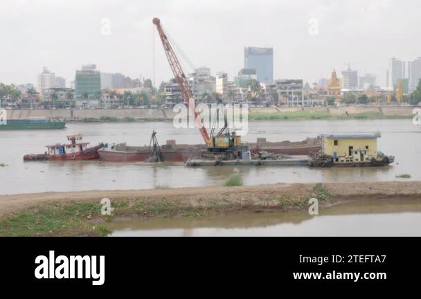 Stationary grab dredger in operation. Dredged sand is loaded into the ...