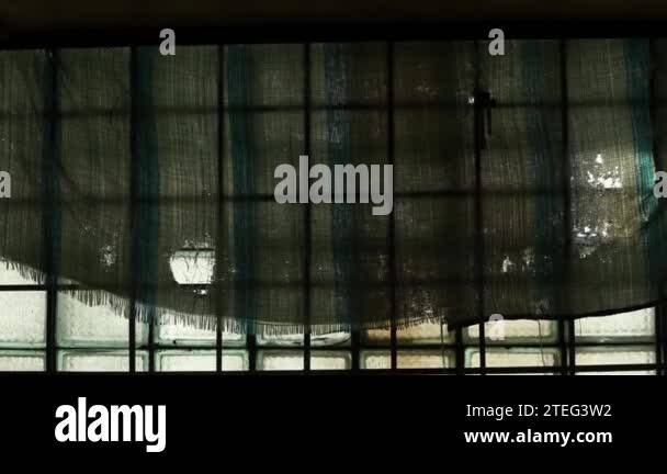 Metal bars on the window of an old industrial building. Dirty window of ...