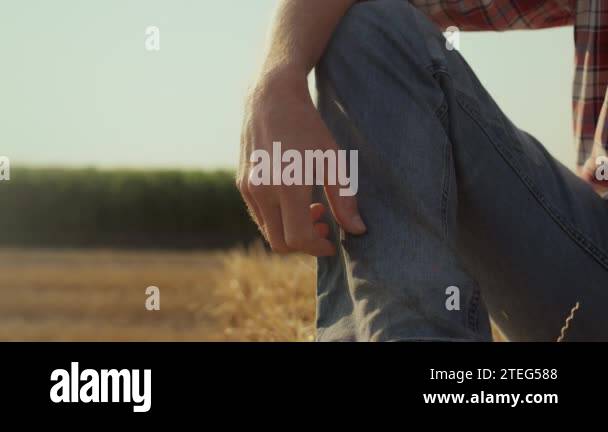 Man leg haystack bale at countryside closeup. Unknown farmer resting ...