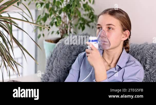 Teenage girl makes inhalation with a nebulizer equipment. Sick child ...