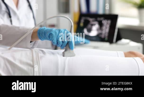 Doctor with a probe on the leg muscle, close-up. Ultrasound of the ...