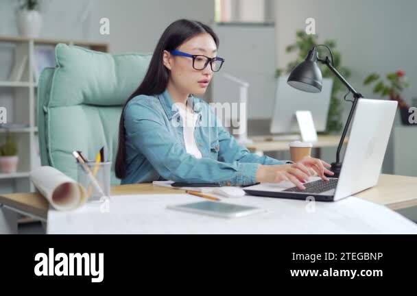 young creative asian woman modern designer or architect sitting at desk ...