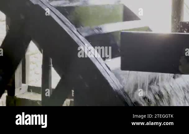 Colonial American water wheel turns with crank shaft in background and ...
