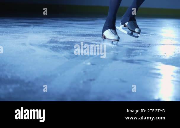 Detailed shot of womens legs in figure skating skates sliding on ice in ...