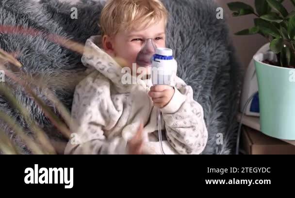 Cute baby boy makes inhalation with a nebulizer equipment. Sick child ...