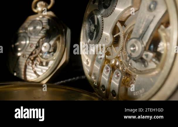 Two antique pocket watches with a working clockwork on isolated black ...