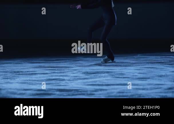 Figure skating lady is skating on ice rink, training at night in the ...