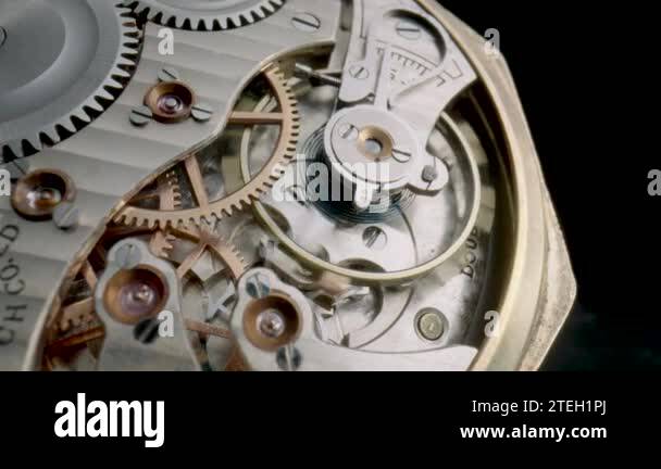 Antique pocket watch mechanism moving on isolated black studio ...
