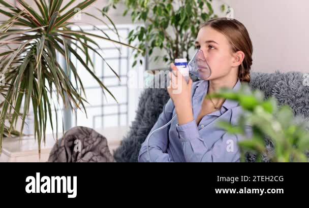 Teenage girl makes inhalation with a nebulizer equipment. Sick child ...