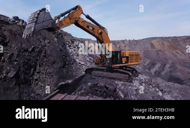Belovo, Russia - May, 2019. Drone view of yellow mine excavator loads ...