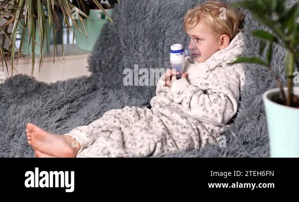 Cute baby boy makes inhalation with a nebulizer equipment. Sick child ...