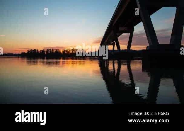 Beautiful golden sunset over a river with a bridge in on the side and ...