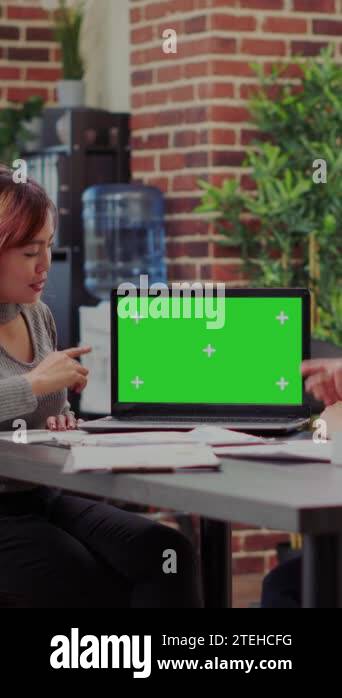 Vertical video: Asian women analyzing green screen on computer in ...