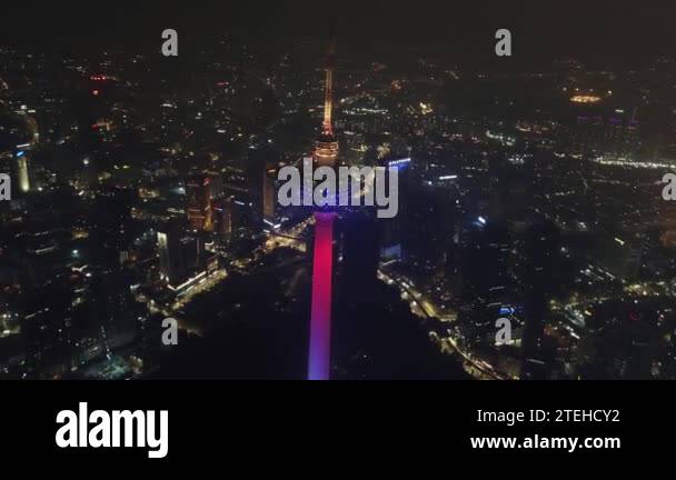 Rotating view of Menara Kuala Lumpur Tower at night. Aerial view of ...