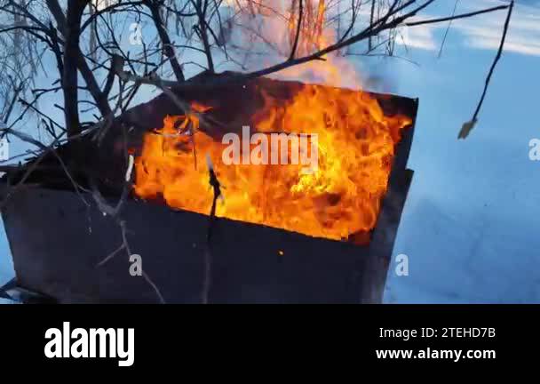 Fire in a metal barrel. Burning garbage in an iron container in winter ...