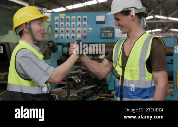 At a manufacturing factory, an industrial engineer operates a control ...
