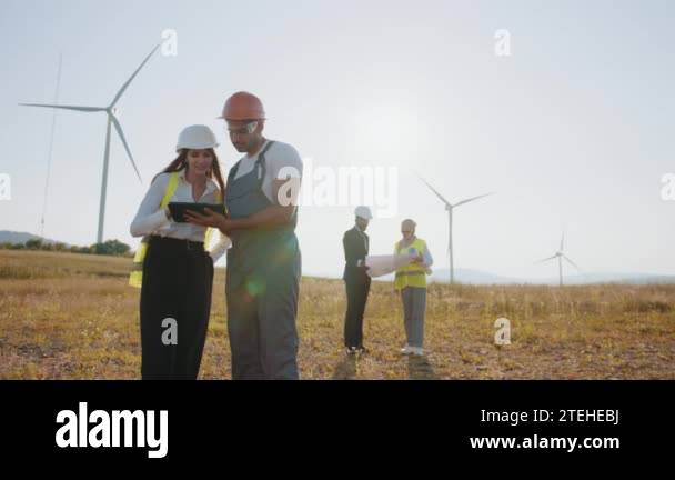 Team of multiracial industrial workers in safety helmets controlling ...