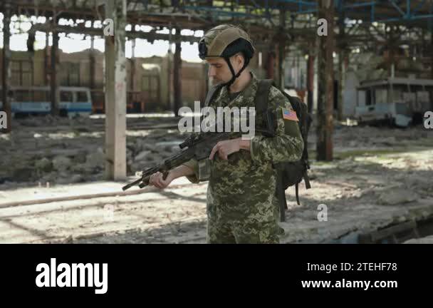 Male officer from US army standing with assault rifle in hands among ...