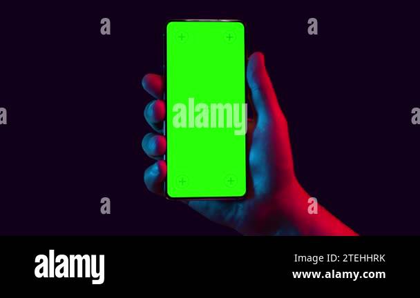 Mobile phone in hand. Holding smartphone with red blue neon lighting on ...