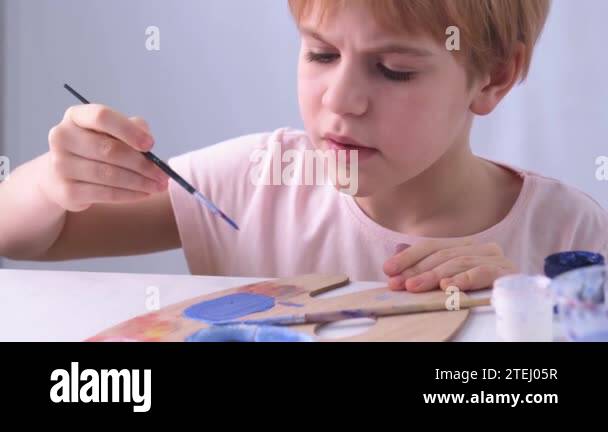 Close-up of the child artists face. A small talented man diligently ...