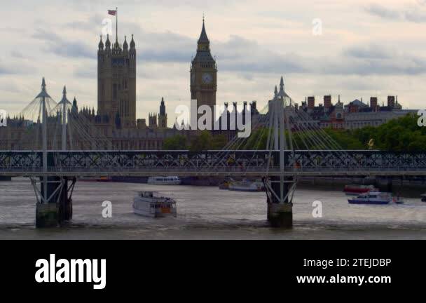 A stationary shot of a train passing over Hungerford Bridge in London ...
