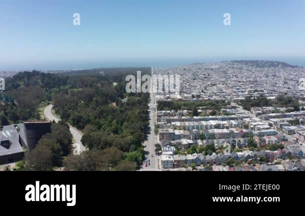 Wide aerial shot flying over a street equally dividing Golden Gate Park ...