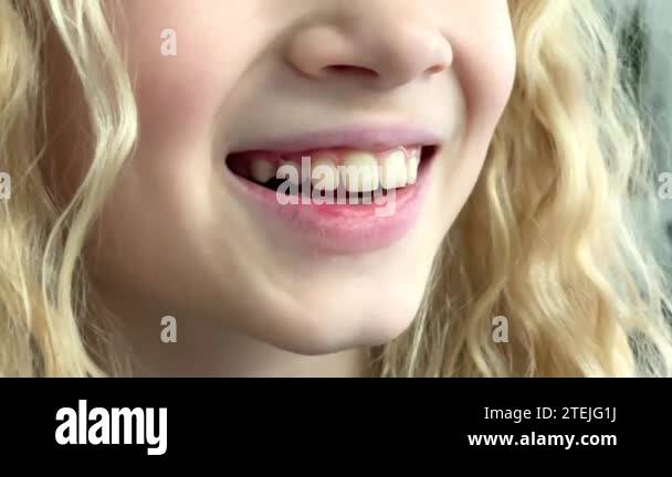 Blonde caucasian baby girl shaking tongue milk tooth in mouth, children ...