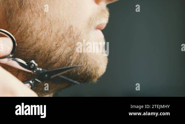 Mans mustache is trimmed with scissors. Close-up, front view, chin and ...