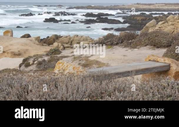 Rocky craggy ocean coast, sea waves, Monterey California. Wooden empty ...