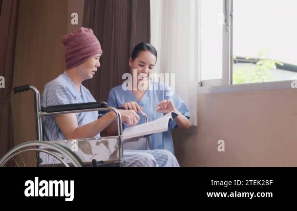 Uniformed young Asian female therapy doctor motivates wheelchair male ...