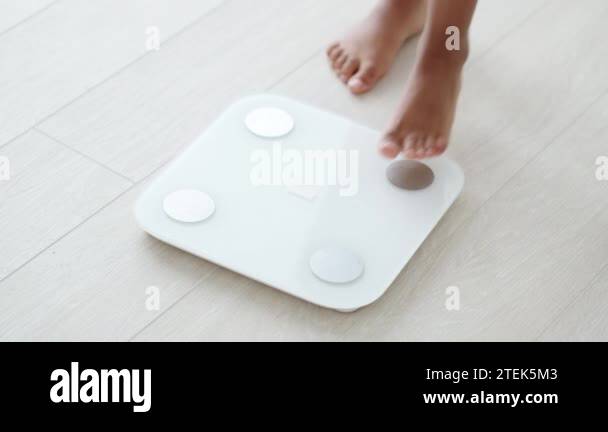 Legs of black girl standing on scale to measure weight. African ...