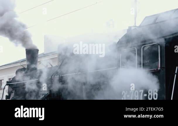 Steam locomotive train approaching station passing through goods yard ...
