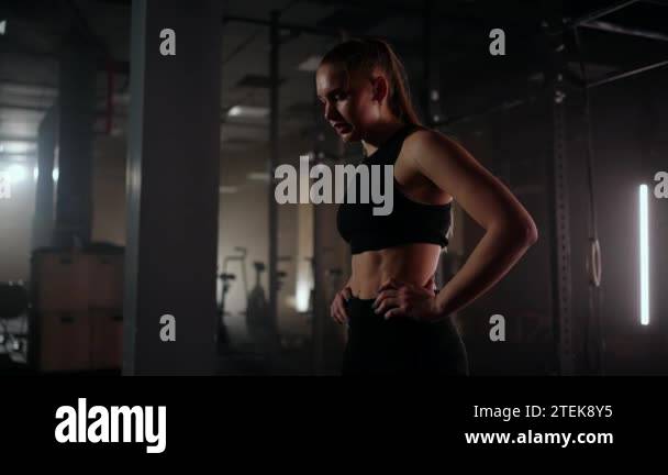 Slow motion: A tired woman recovers strength in training after an ...