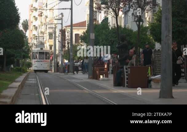 Running tram and walking people on the city street. City life concept ...