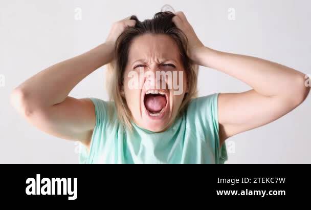 Young woman screaming and tearing her hair out on white background 4k ...