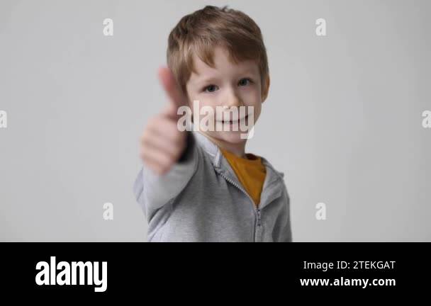Child shows thumbs up gesture, happy facial expression emotion glad ...