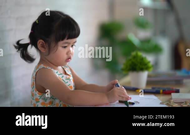 Asian baby girl drawing with colourful crayon , happy funny child girl ...
