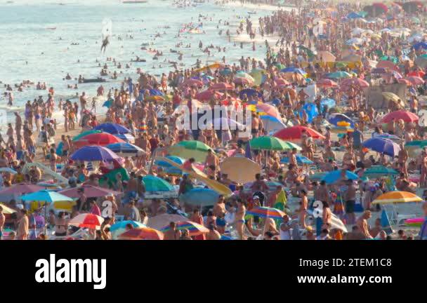 Lots people on the beach full masses travelers. Many people relaxing ...