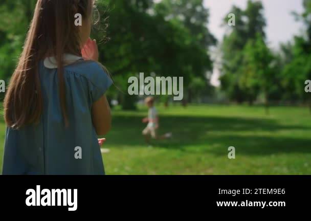 Funny girl scratching nose on sunny park. Cute child wiping face rear ...