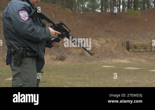 Police officer reloads his assault rifle during target practice at a ...