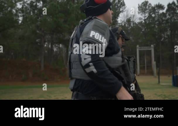 A SWAT team of police officers walk up to a gun range with their ...